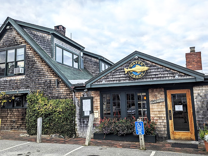 A weathered cedar-shingled haven beckons with its golden fish sign, promising the kind of coastal comfort that makes Maine, well, Maine. Photo credit: Lawrence Marcus