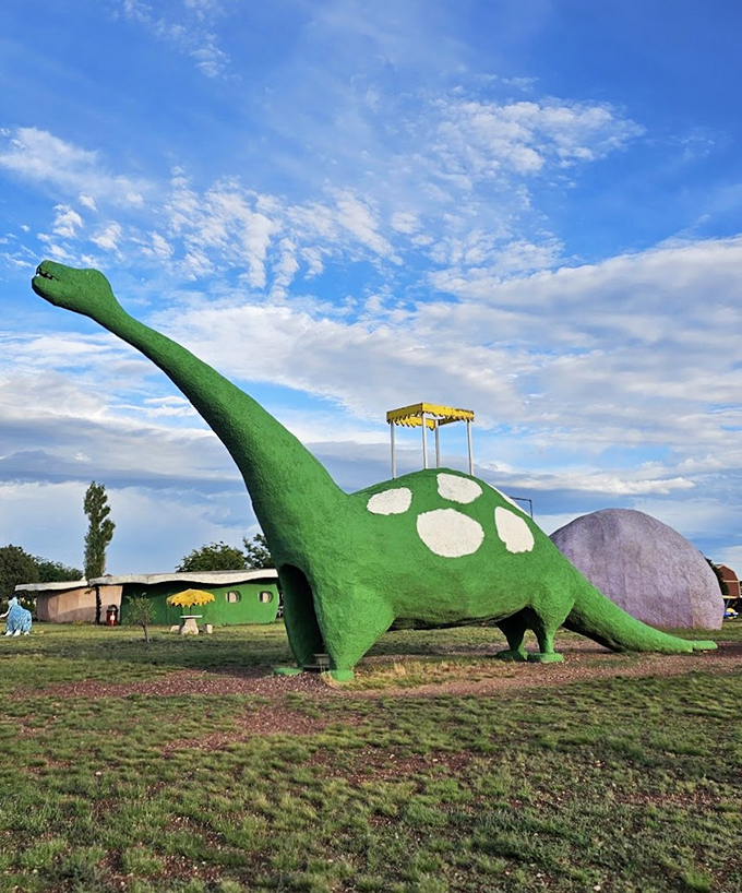 A friendly green dinosaur stands guard, complete with polka dots and a viewing platform&mdash;prehistoric fun meets modern whimsy.