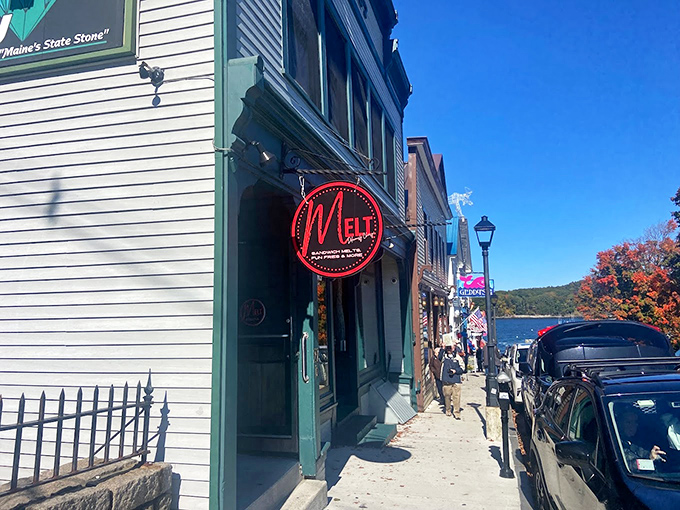 A charming white building with green trim and a bold red neon sign beckons hungry visitors along Bar Harbor's waterfront.