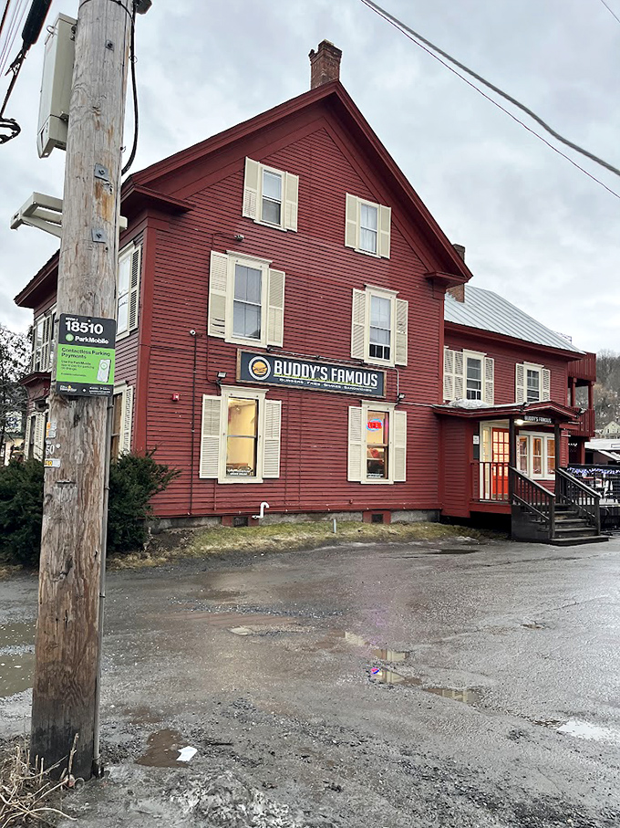 Housed in a classic red Vermont building, Buddy's Famous stands like a beacon of comfort food against the mountain backdrop, welcoming hungry travelers home.