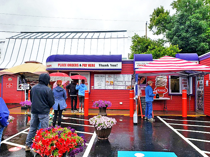 Even on a rainy day, locals line up under umbrellas at this cheery red seafood spot, where colorful flowers brighten the wait.