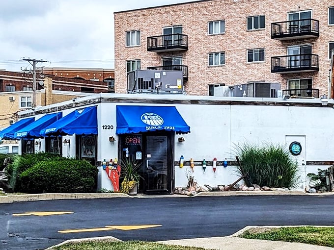 A humble storefront with bright blue awnings promises seafood treasures within - like finding a pearl in an unexpected oyster.