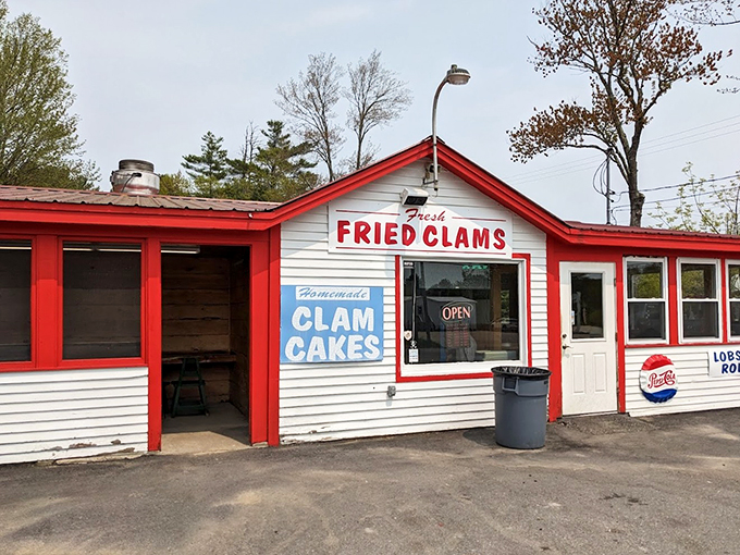 A classic Maine seafood shack in red and white, proudly announcing its treasures with signs that practically shout "Fresh fried clams ahead!"
