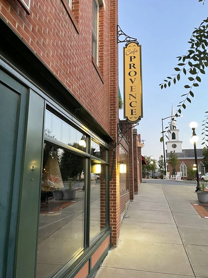 A sunny yellow sign beckons from the brick facade, promising French delights in downtown Brandon. The church steeple in the background adds that perfect small-town Vermont charm.