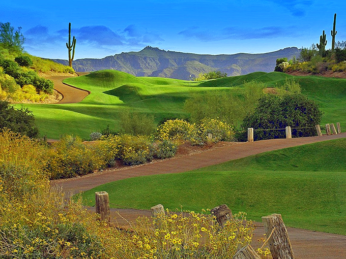 A golfer's paradise meets nature's masterpiece. Emerald fairways wind through golden desert, with saguaros standing sentinel against rugged mountains. Jurassic Park meets Augusta National!