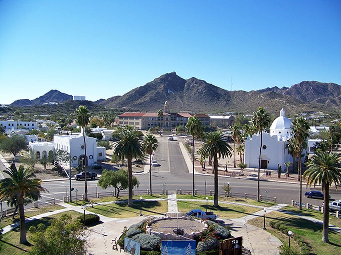 Ajo's historic plaza unfolds like a Spanish colonial dream, with palm trees standing guard and mountains painting the perfect backdrop. Photo credit: Kizarny
