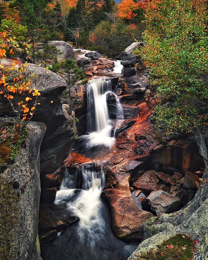Nature's own masterpiece: Screw Auger Falls cascades through autumn-painted rocks, creating a scene that would make Bob Ross reach for his brushes.
