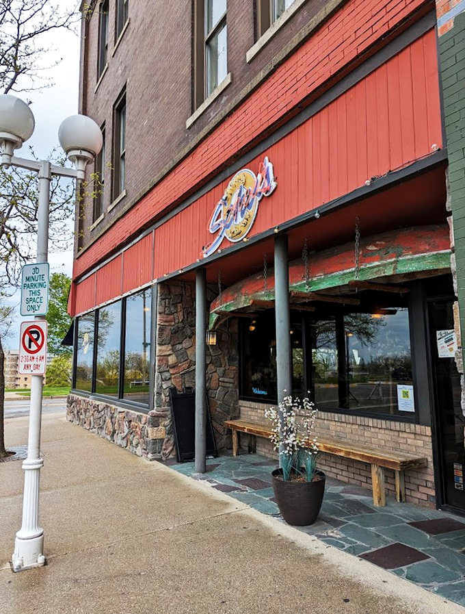 The classic brick-and-stone facade feels like stepping into a cozy corner of small-town Michigan, complete with charming wooden benches and welcoming planters.