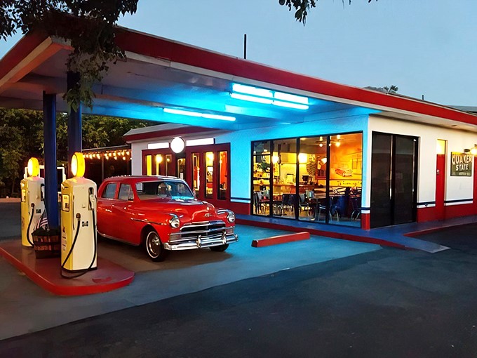 Step back in time! This neon-lit oasis isn't just serving burgers &ndash; it's dishing out a heaping helping of 1950s nostalgia, complete with a cherry-red classic car.