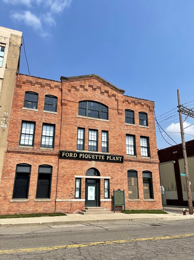 A brick fortress of automotive history! The Ford Piquette Plant stands proud, its windows gleaming like chrome on a freshly polished Model T.
