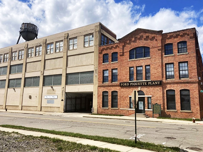 A brick fortress of automotive history! The Ford Piquette Plant stands proud, its windows gleaming like chrome on a freshly polished Model T.
