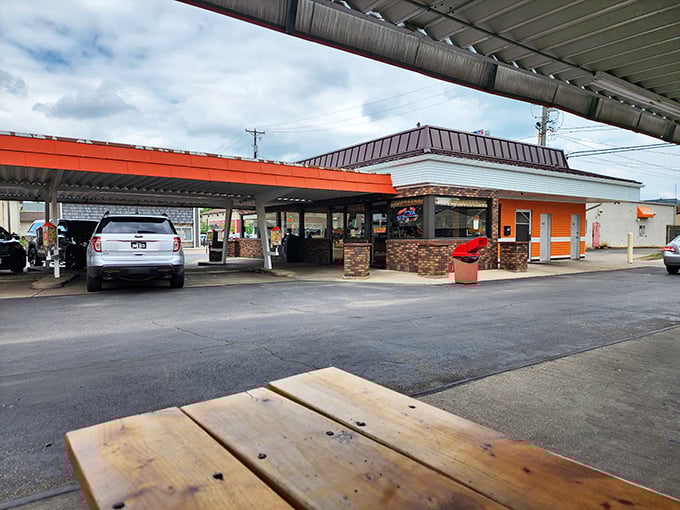 Step into a time machine disguised as a drive-in! Rudy's orange and white facade beckons like a beacon of nostalgia, promising delicious adventures ahead.