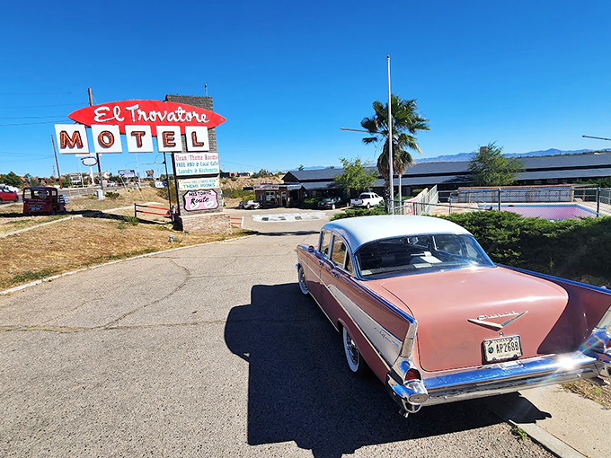 Welcome to the time machine! El Trovatore Motel's iconic sign beckons travelers to step back into the golden age of Route 66, complete with a classic car that's ready to hit the road. 