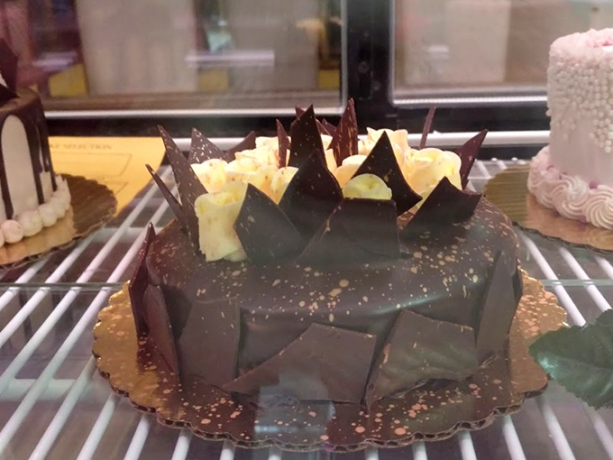 Dark chocolate shards rise like modern art from this cake, proving that sometimes dessert can be both dinner conversation and centerpiece.