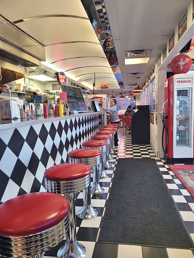 The counter stretches like a chrome runway, each stool promising the best seat in the house for breakfast theater.