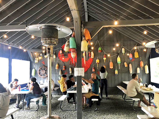 Happiness is a full belly and a view! These diners are living their best lives, surrounded by nautical charm and the promise of seafood bliss.