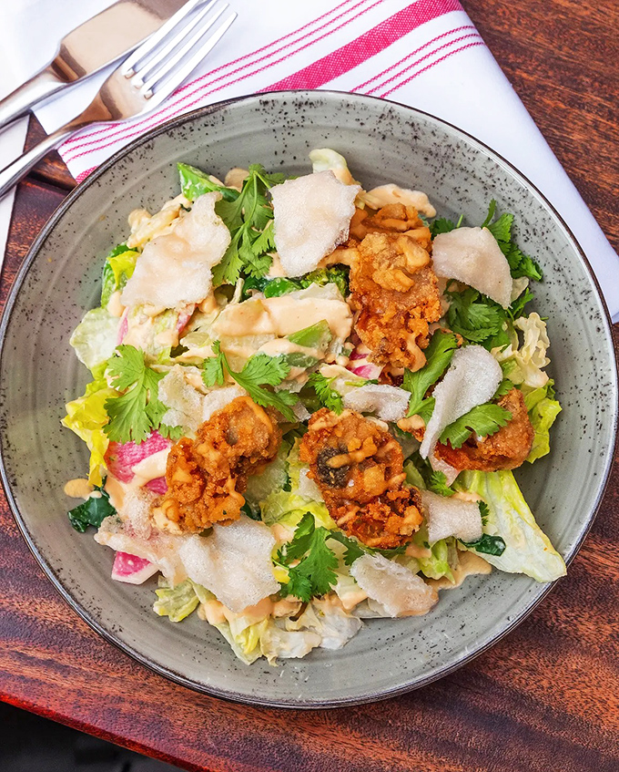 Golden-fried oysters crown a fresh salad, bringing crunch and brine to every perfectly composed bite.