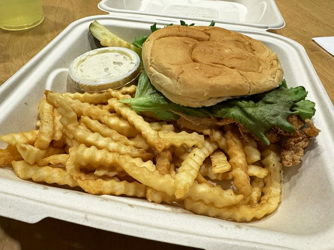 Crispy waves of crinkle-cut fries escort a golden-crusted haddock sandwich to seafood satisfaction.