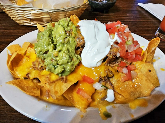 A mountain of nachos crowned with guacamole, sour cream, and fresh pico de gallo - sharing optional but highly recommended.