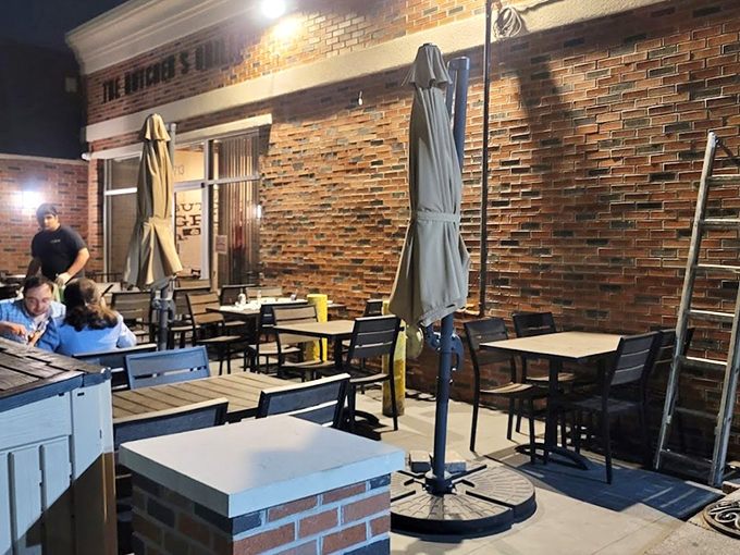 A cozy patio setup where brick walls and umbrellas create the perfect spot for al fresco dining.