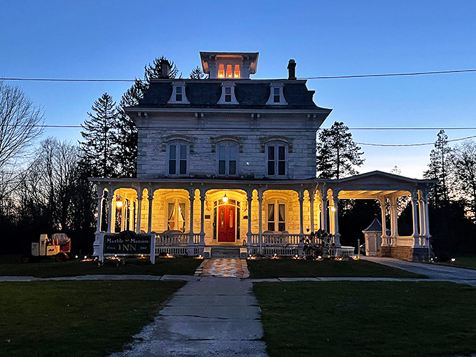 As twilight embraces the mansion, warm lights transform this architectural grande dame into a beacon of hospitality against the Vermont night.