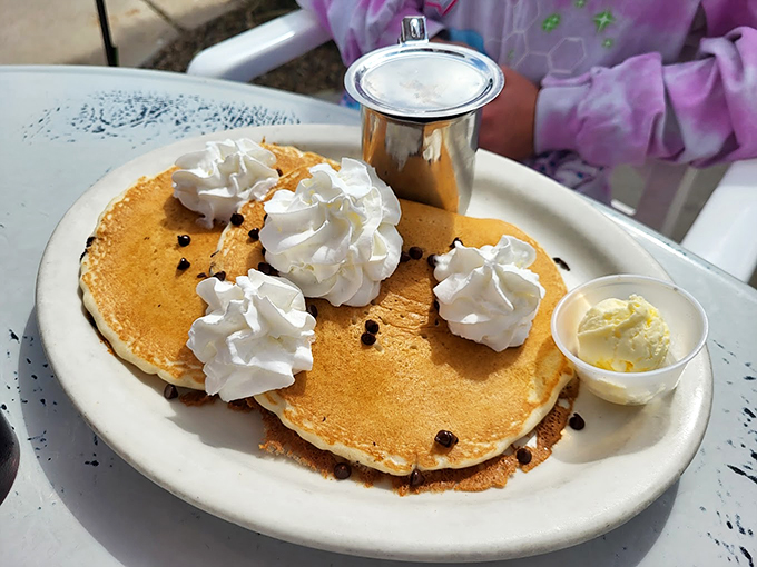 These chocolate chip pancakes wear their whipped cream clouds like badges of honor. Pure breakfast indulgence at its finest. Photo credit: Rick Bee