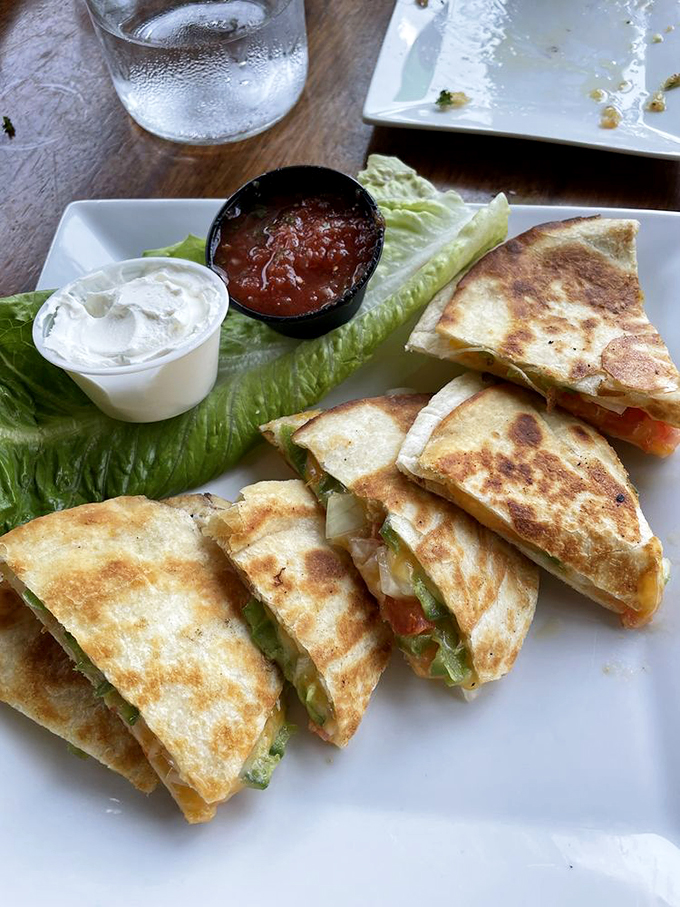 Crispy quesadillas filled with melted cheese and fresh vegetables, served with cool sour cream and zesty salsa. Photo credit: Linda R.