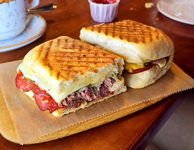 A grilled sandwich that's living its best life, packed with layers of deliciousness between perfectly toasted bread.