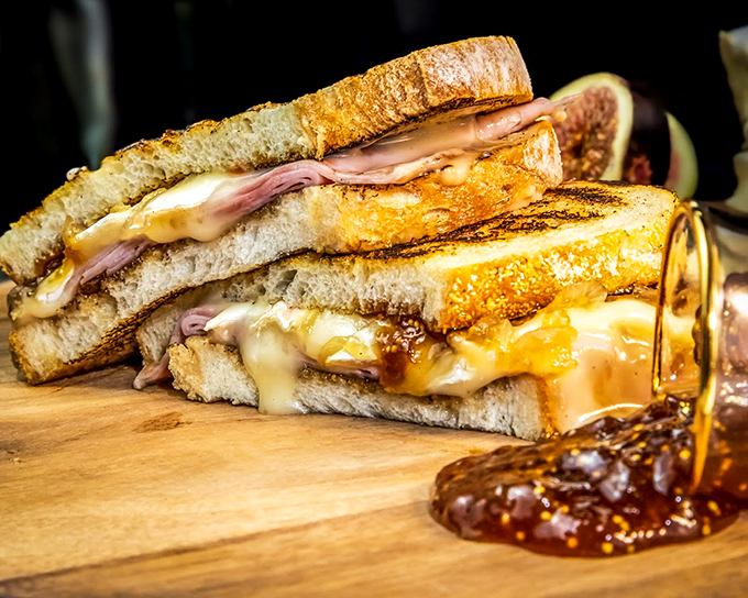 Melted cheese cascades like a golden waterfall in this grilled sandwich that puts airline food carts to shame.
