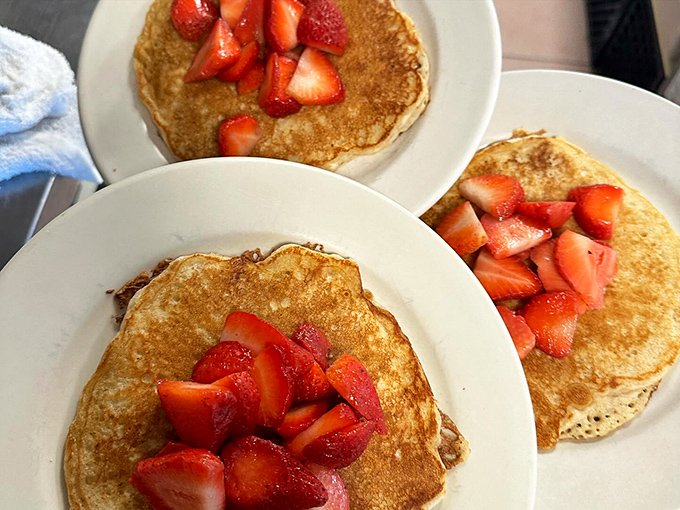 Pancakes that could make maple trees jealous. These fluffy stacks, crowned with fresh strawberries, are the stuff of breakfast dreams.
