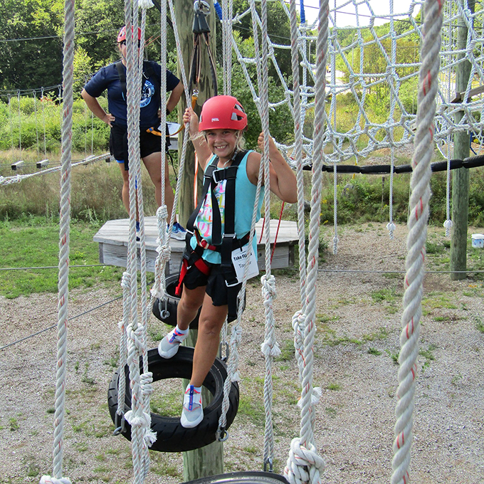 Smiles shine brightest when you're conquering obstacles that looked impossible from the ground. Photo credit: Take Flight Aerial Adventure Park