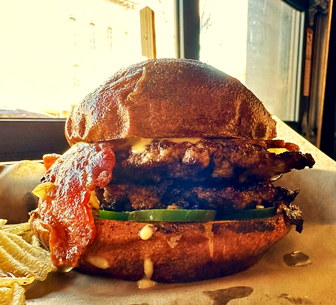 Holy cow! This burger is stacked higher than a Jenga tower, and twice as likely to make you topple over with joy.