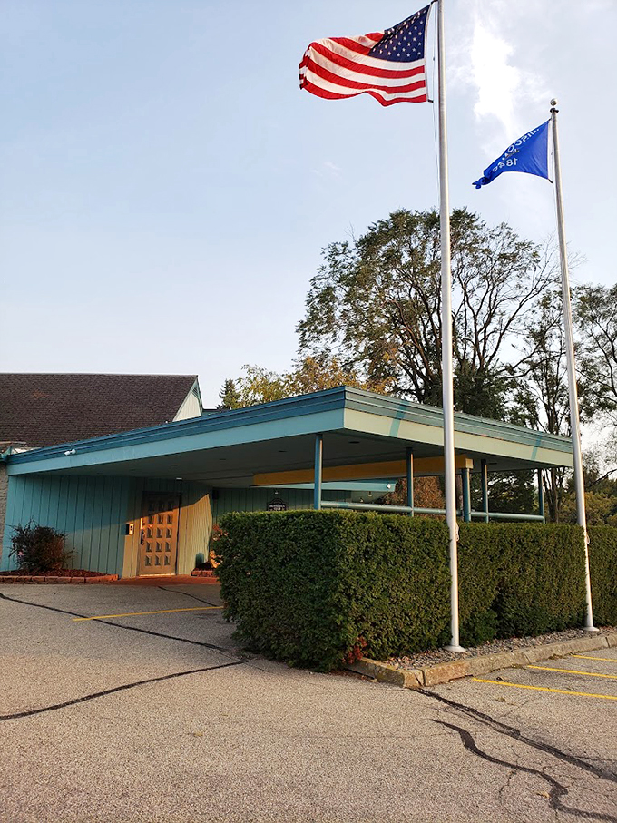 Classic mid-century architecture meets Midwest hospitality under waving flags, where the turquoise trim and manicured hedges welcome diners to this timeless supper club. 