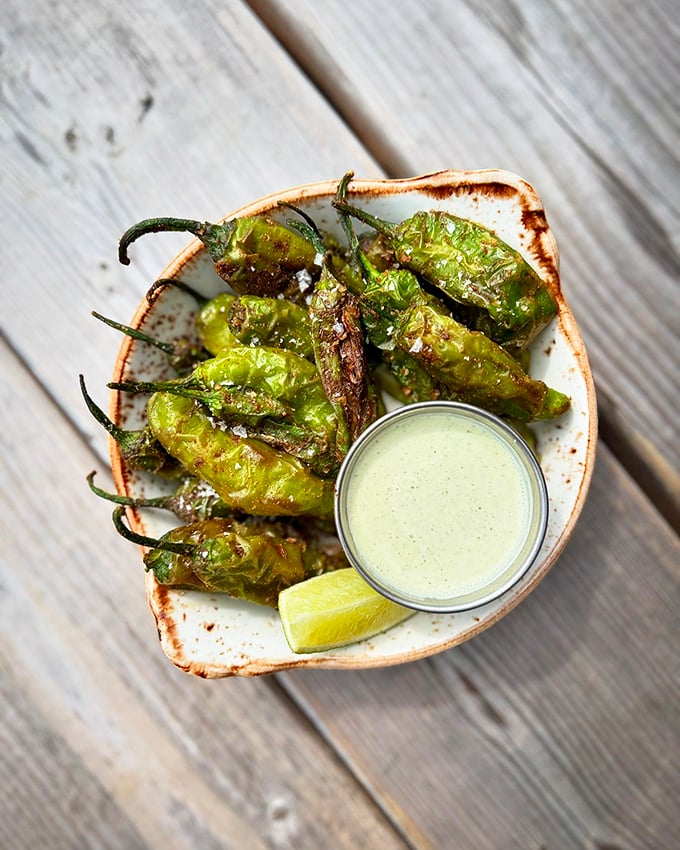 Blistered shishito peppers playing pepper roulette &ndash; most are mild, but someone's getting the spicy surprise!