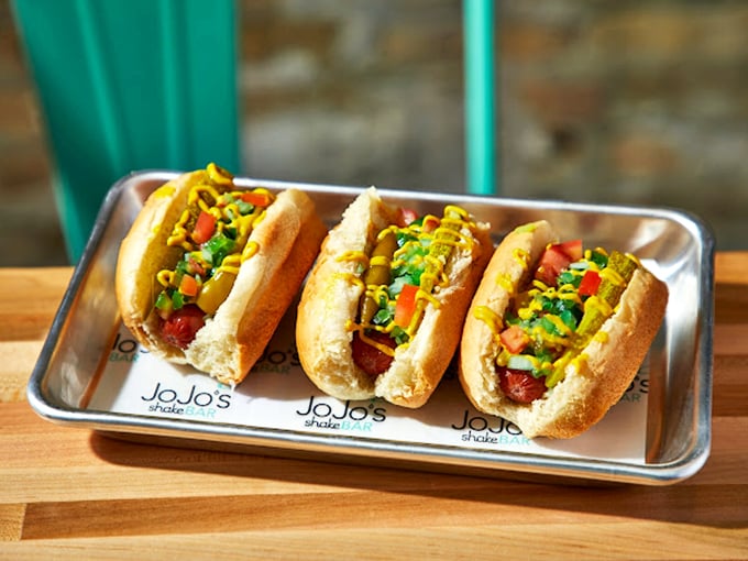 These aren't just hot dogs&mdash;they're works of art, dressed to impress with vibrant toppings and served on gleaming metal trays. 