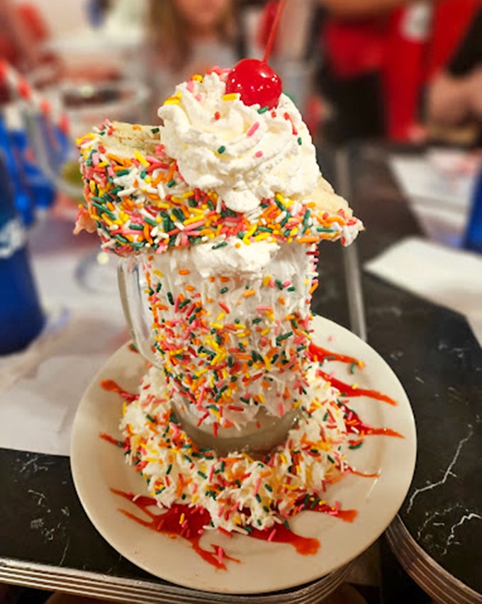 A towering creation crowned with whipped cream and sprinkles proves that some desserts are meant to be photographed first.