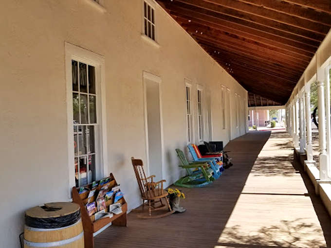 Rocking chairs line the shaded porch, inviting visitors to pause and ponder life in territorial Arizona.