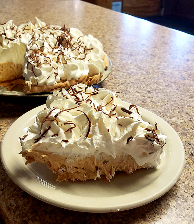 Peanut butter lovers, rejoice! This pie is nutty nirvana, crowned with a swirl of whipped cream that's practically begging for its close-up. Photo credit: Beeline Cafe