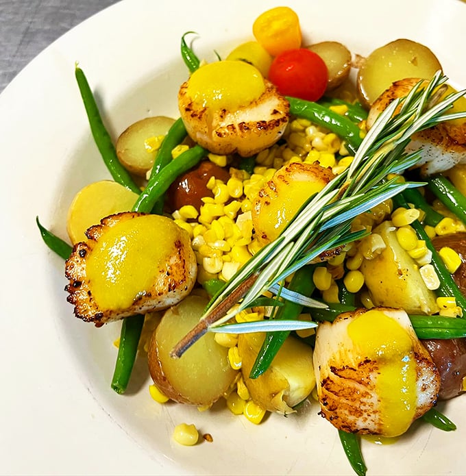 Perfectly seared scallops mingle with sweet corn and green beans - summer on a plate, Vermont style. 