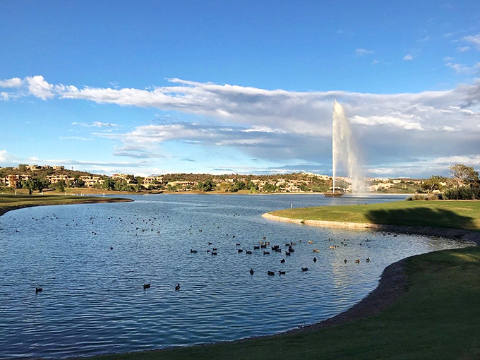 A patchwork of desert homes and verdant spaces creates a stunning contrast against the rugged mountain backdrop.