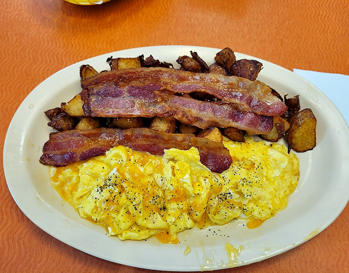 Bacon, eggs, and home fries - the holy trinity of breakfast. This plate is like a warm, edible hug for your taste buds.