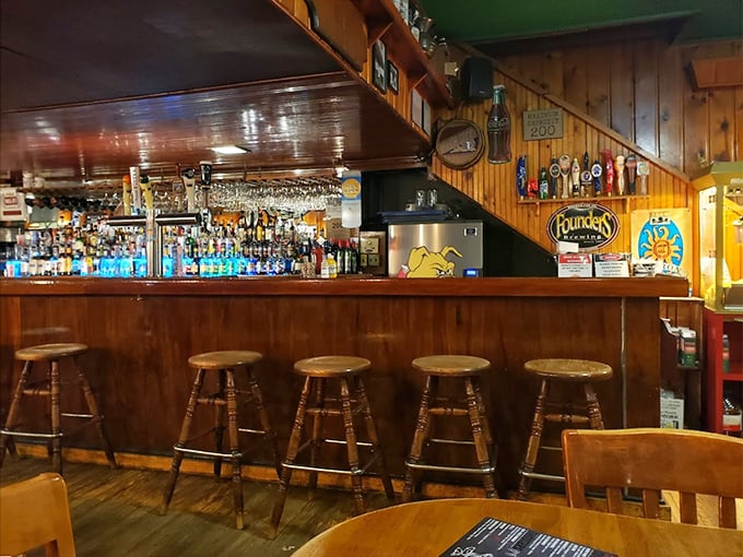 Classic wooden stools await their next story while bottles sparkle in the background.