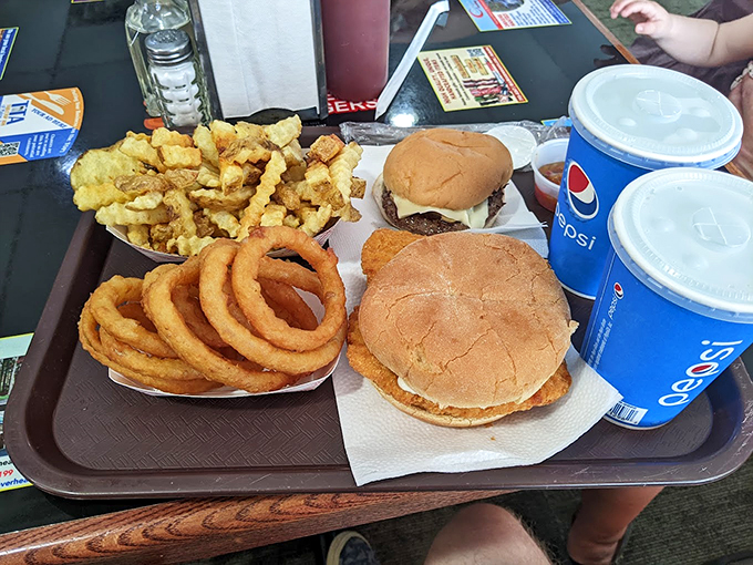The holy trinity of diner perfection: burgers, rings, and fries, with Pepsi standing guard to wash it all down.