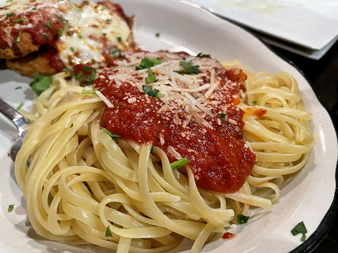 Perfectly cooked linguine supports its crispy-coated companion in a sea of vibrant marinara sauce.