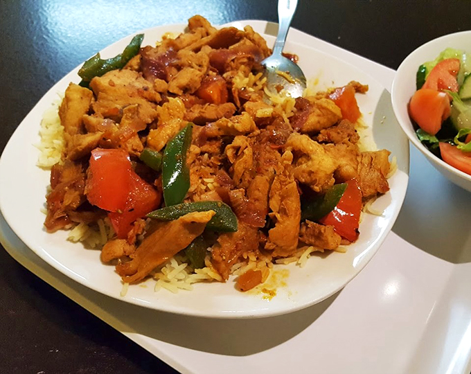 Tender chicken transforms humble rice into a feast fit for royalty, with fresh vegetables adding pops of color and crunch.