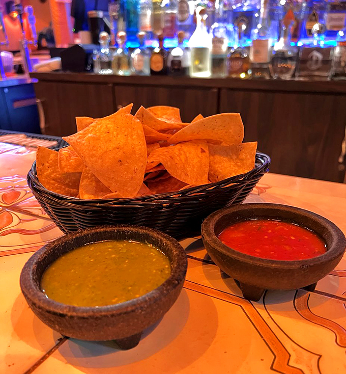 Crispy tortilla chips stand ready for their date with two perfect salsas - one verde, one roja, both irresistible.