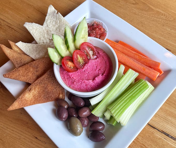 A rainbow of fresh veggies and vibrant beet hummus proves seafood isn't the only star here.