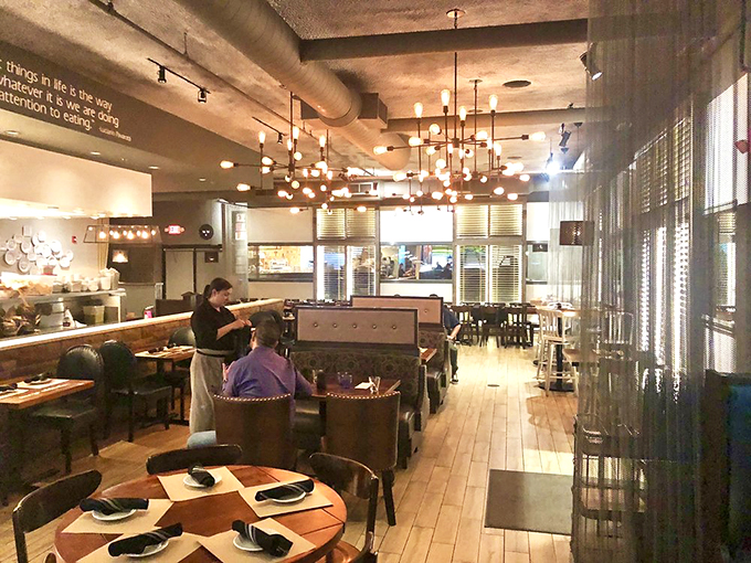 Modern chandeliers cast a warm glow over the dining room, where every table feels like the best seat in the house.