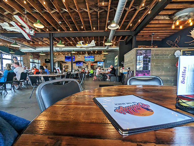 Model planes soar overhead while string lights twinkle below, creating an atmosphere that's pure Michigan magic.