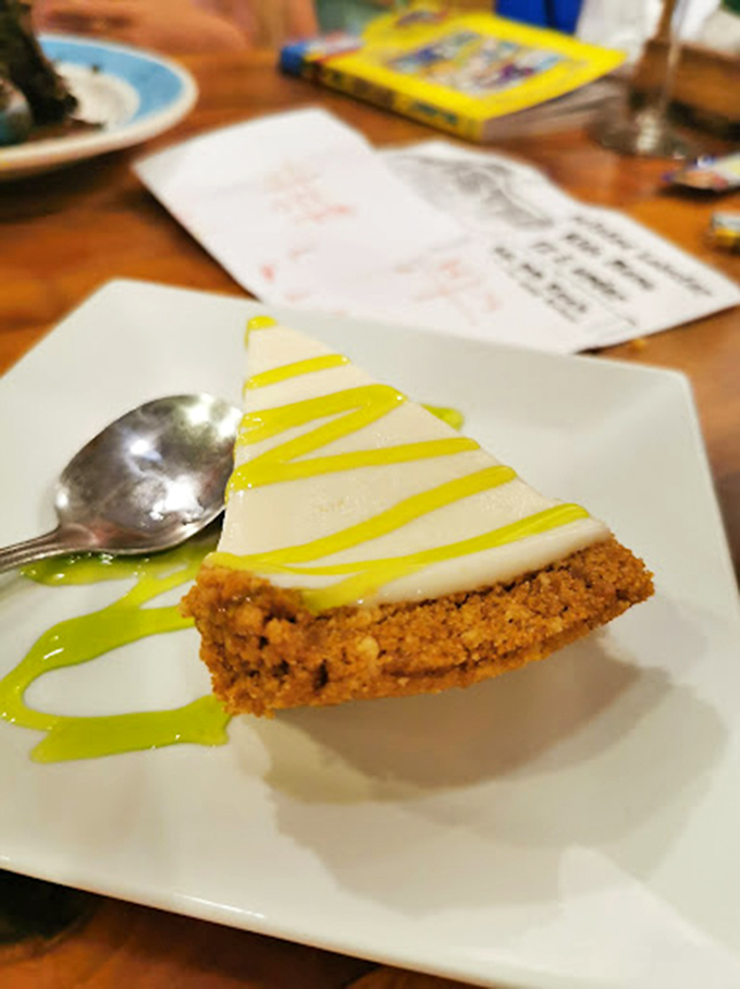 A slice of Florida sunshine: creamy key lime pie drizzled with citrus sauce on a golden graham cracker crust.